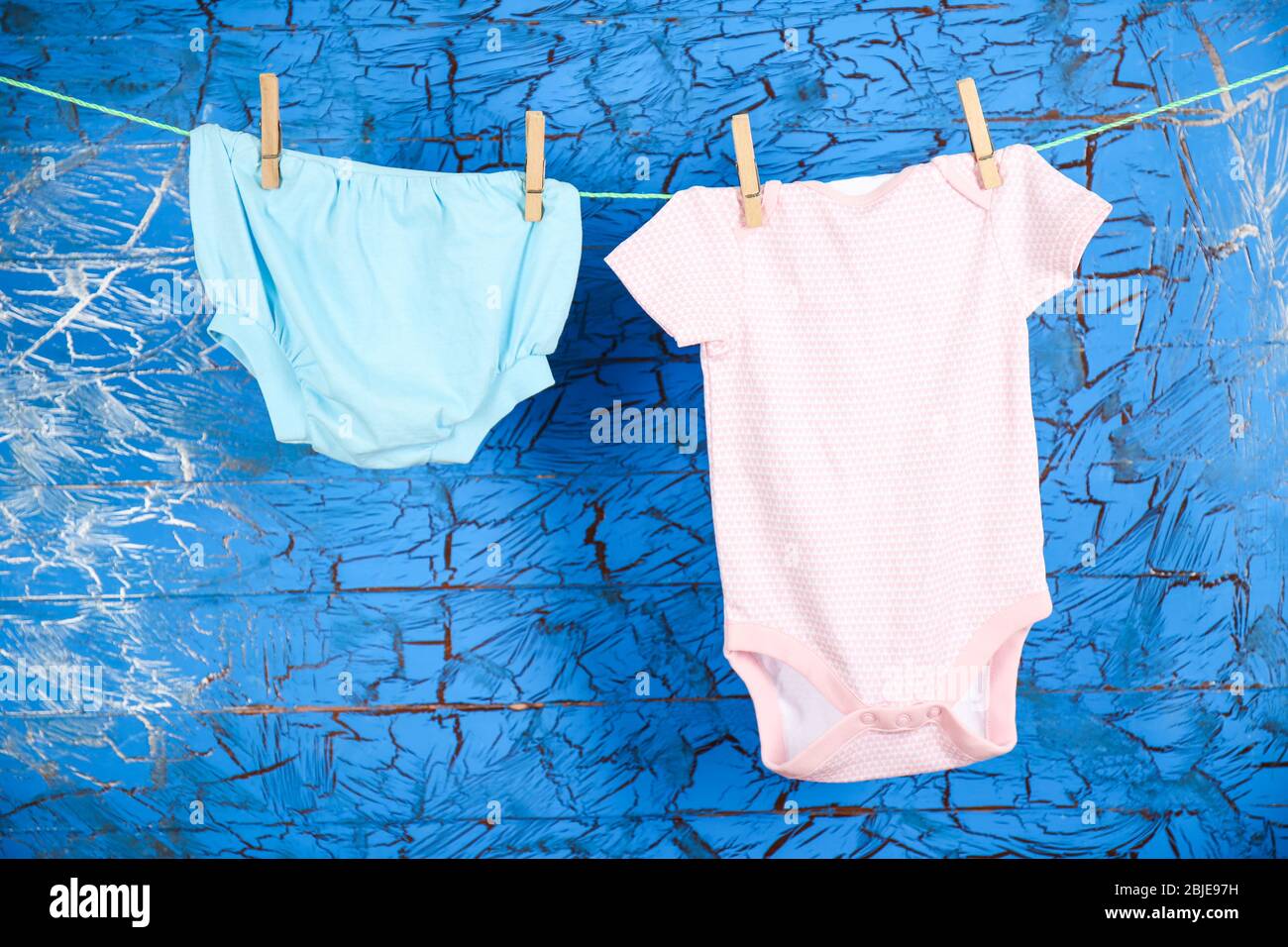 Baby clothes on blue background Stock Photo - Alamy