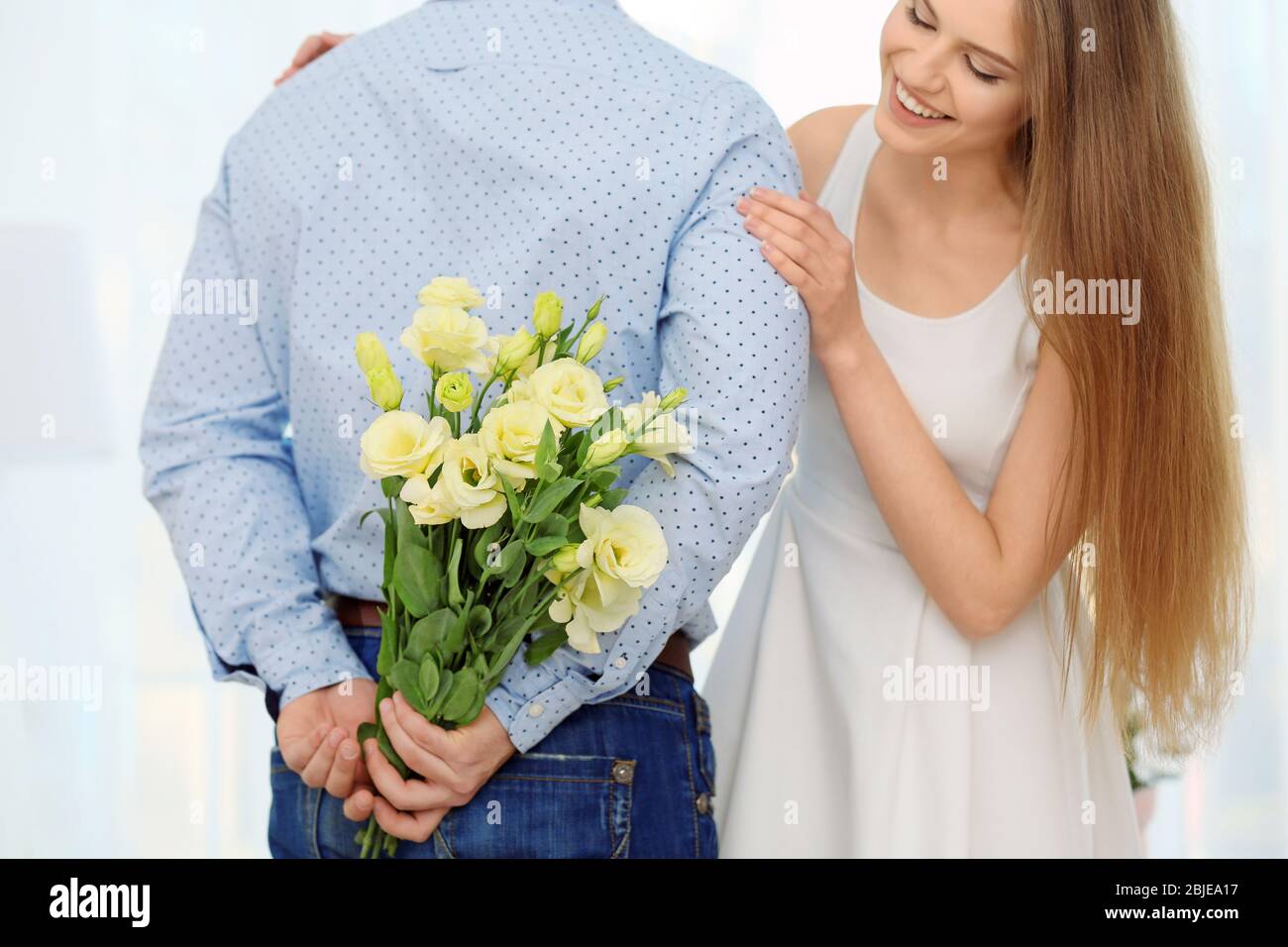 Man hiding flowers behind his back hi-res stock photography and images ...