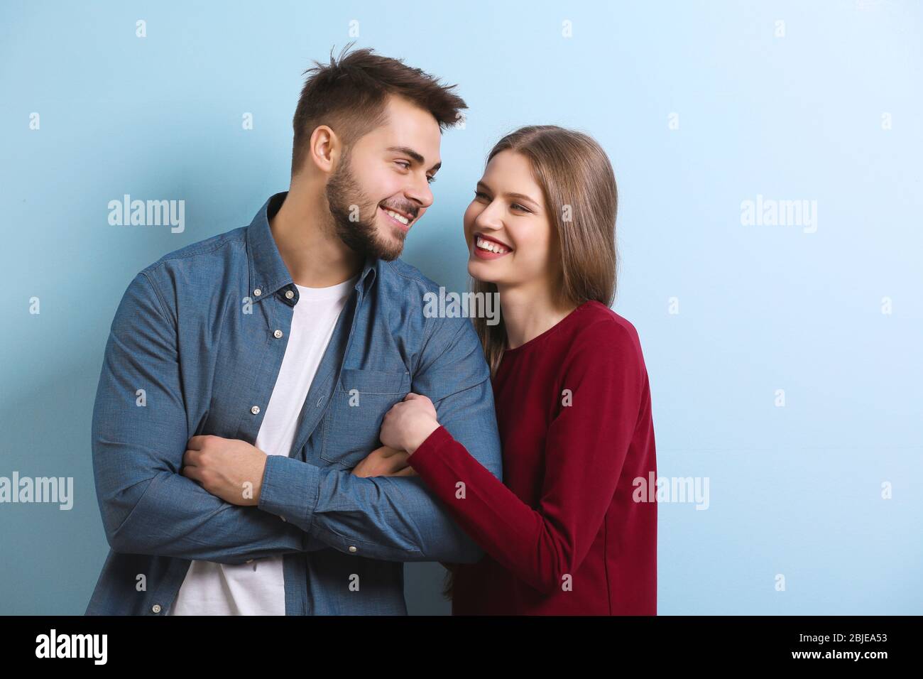 Cute young couple on color background Stock Photo - Alamy