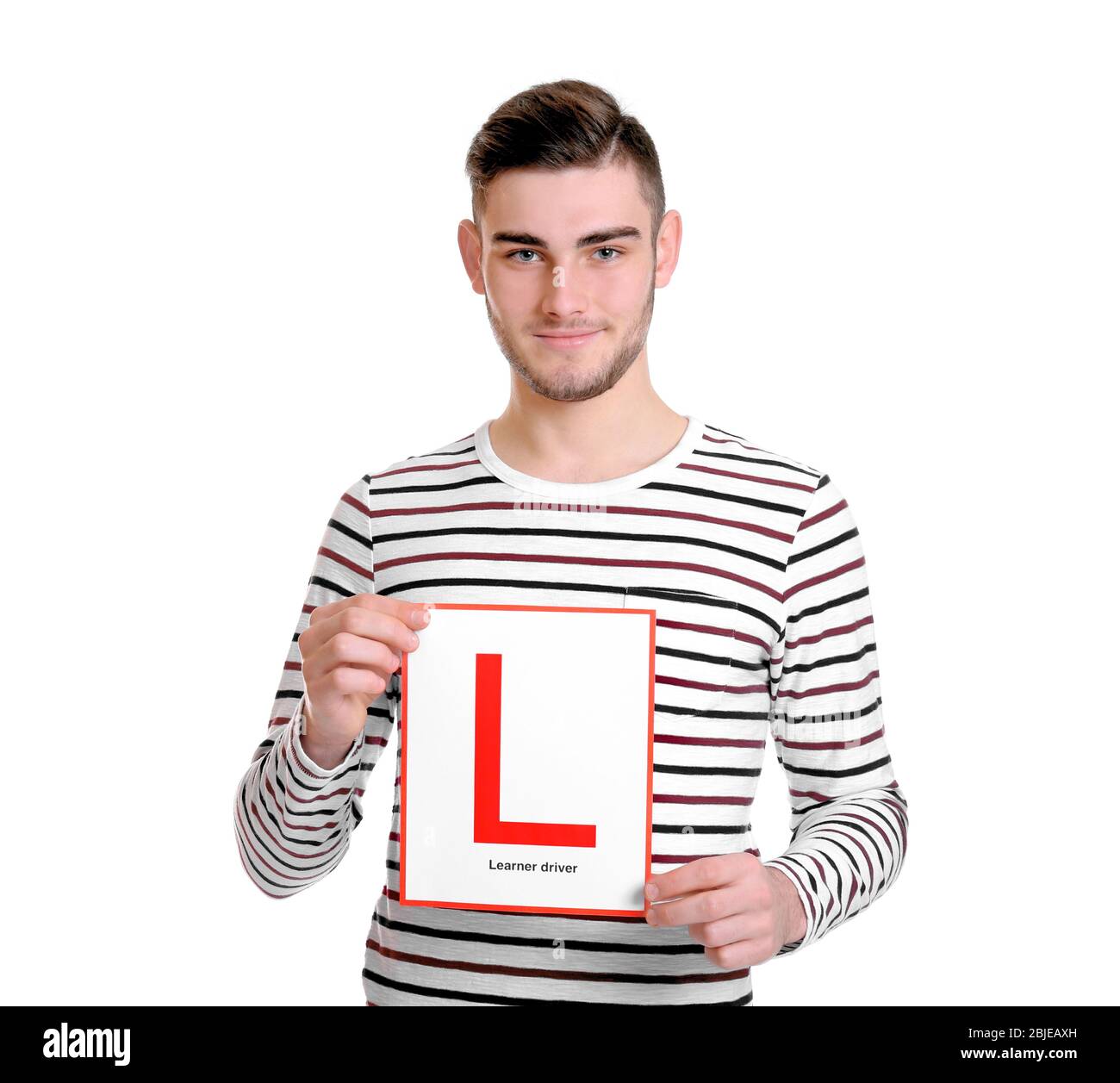 Young man with learner driver sign on white background Stock Photo - Alamy