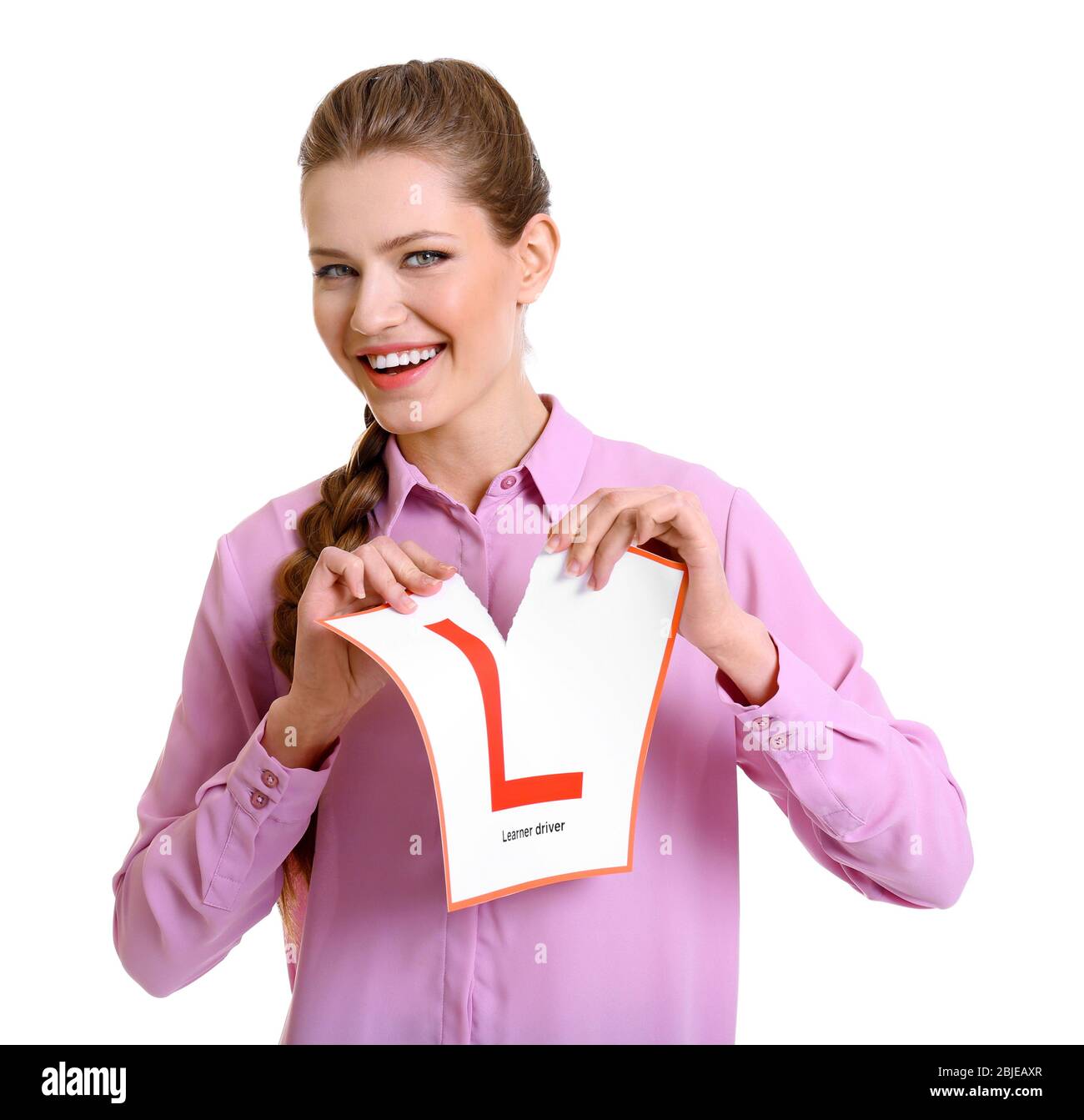 Young woman tearing learner driver sign on white background Stock Photo ...