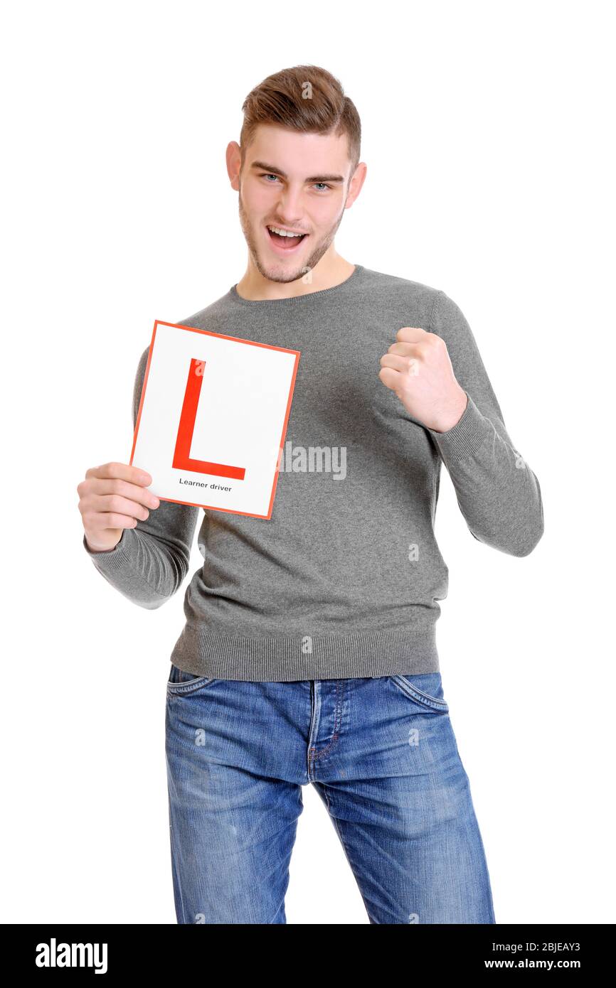 Young man with learner driver sign on white background Stock Photo - Alamy