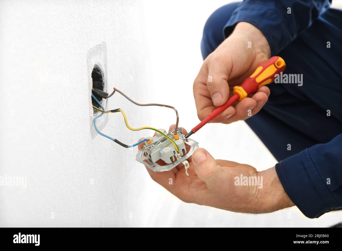 Electrician disassembling wall socket in new building, closeup Stock ...