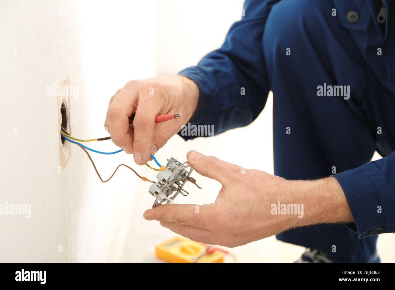 Electrician attaching wires to socket in new building, closeup Stock ...