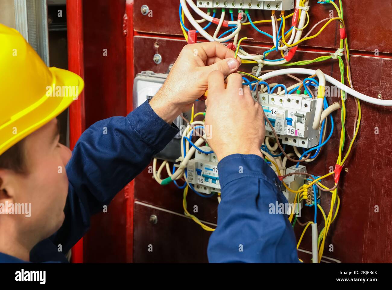 Electrician connecting wires in distribution board Stock Photo - Alamy