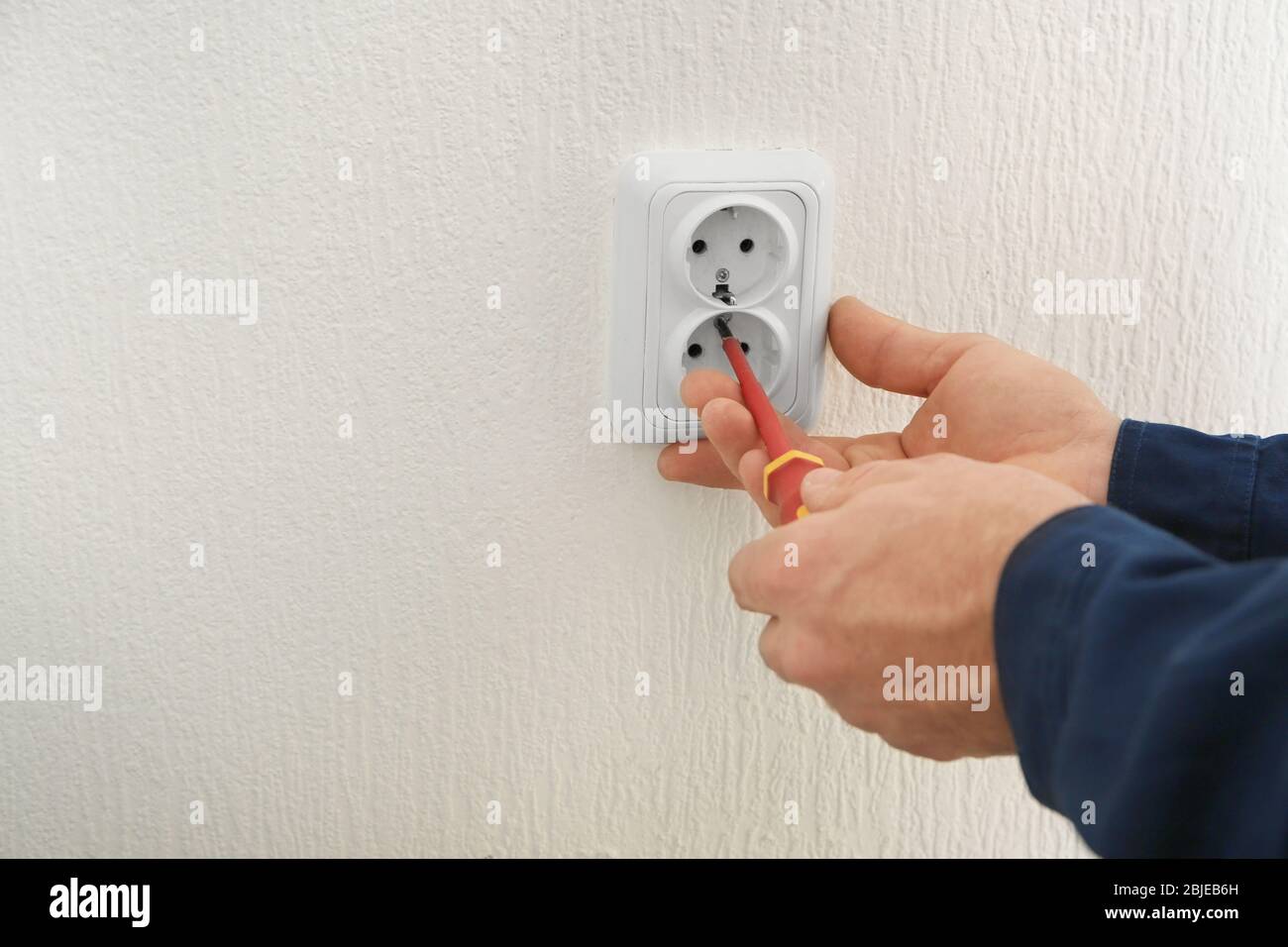 Electrician installing wall socket in new building, closeup Stock Photo ...