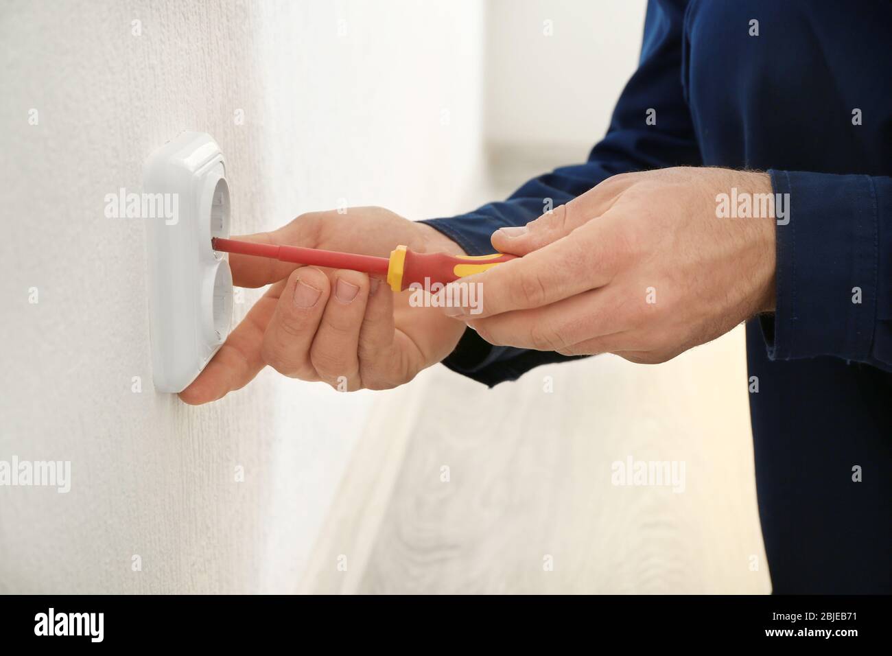Electrician installing wall socket in new building, closeup Stock Photo ...