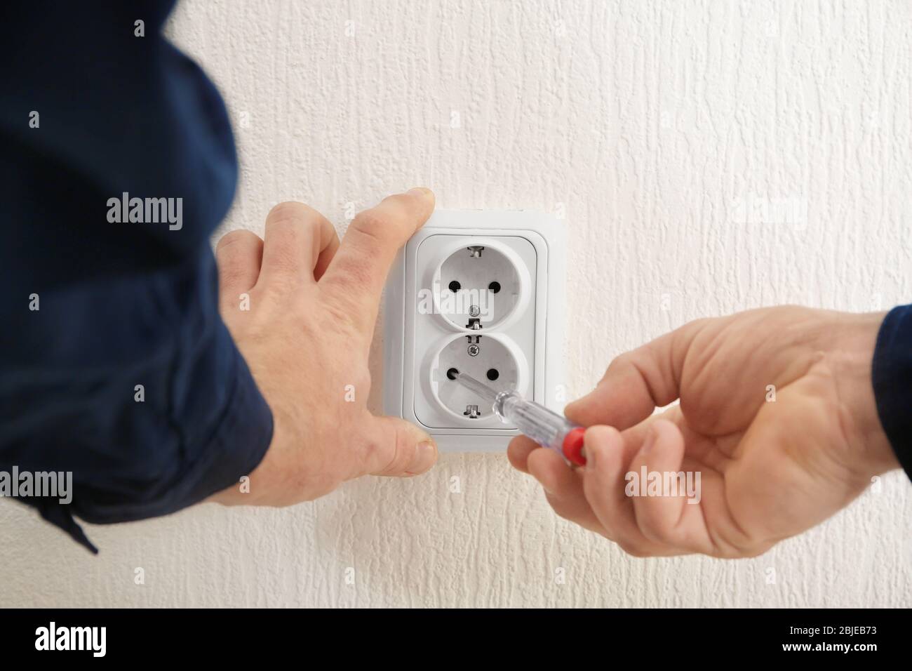 Electrician installing wall socket in new building, closeup Stock Photo ...