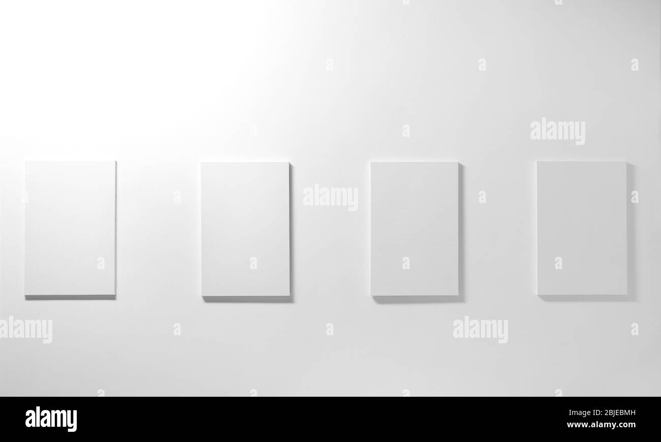 Empty canvases on white wall background Stock Photo - Alamy