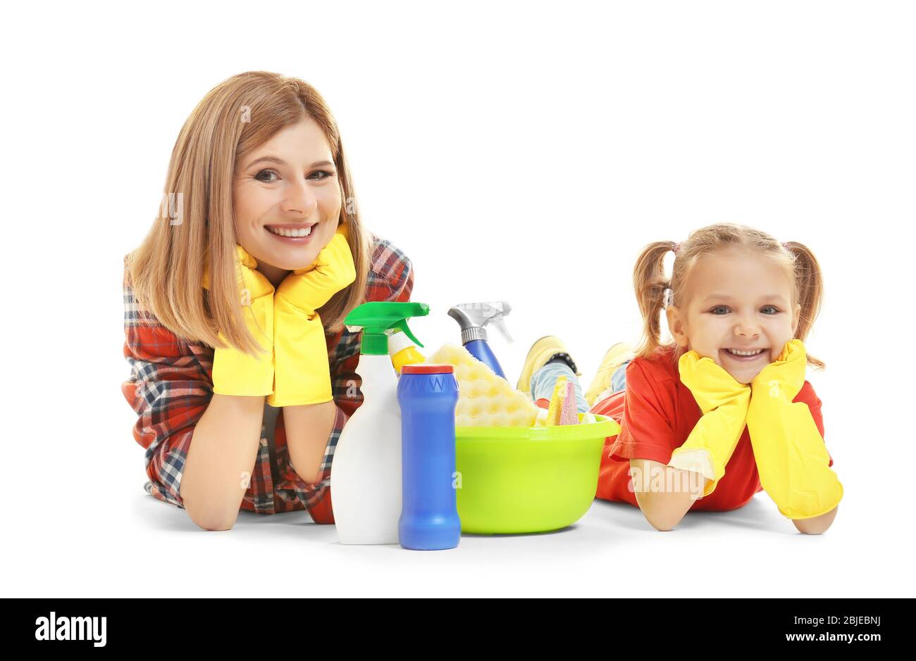 Little girl and her mother with cleaning supplies on white background ...
