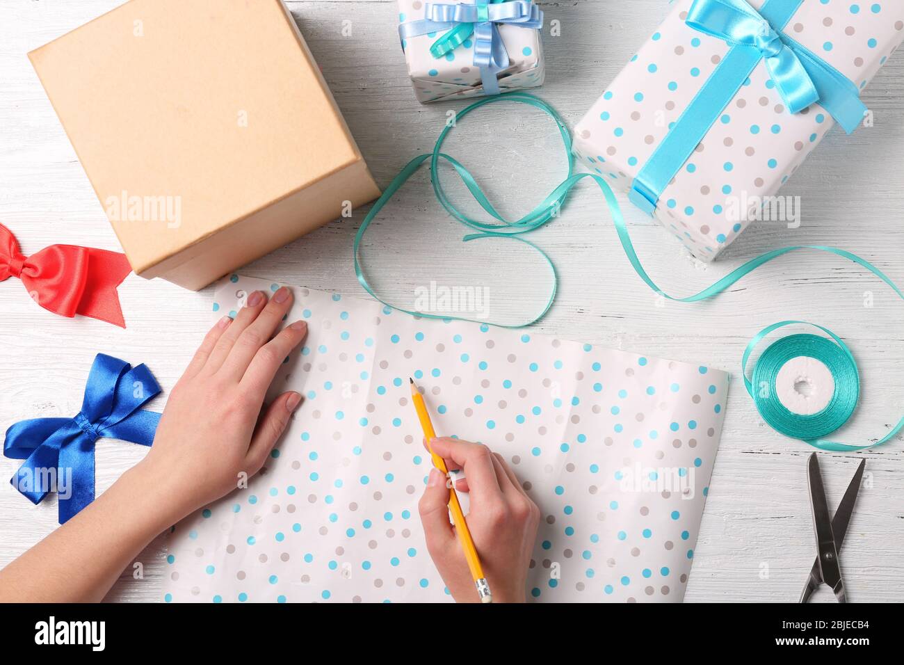 Hands of woman packing presents for holiday Stock Photo - Alamy