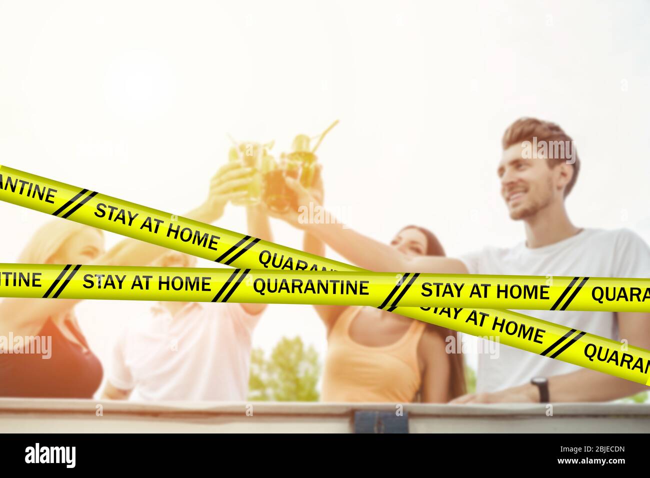 Biohazard Coronavirus yellow warning tapes against friends having fun ...