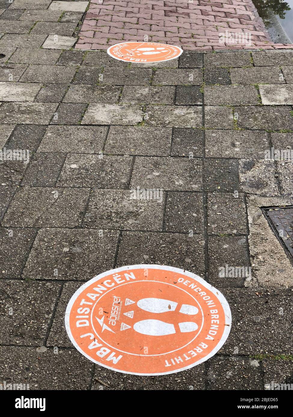 Signs printed on pavement informing people to keep 2 meters distance ...