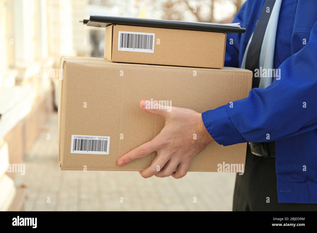 Courier with parcels on doorstep, closeup Stock Photo - Alamy