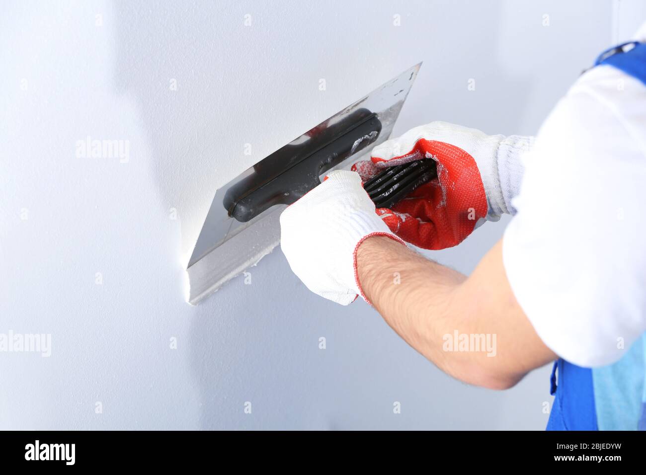Builder using plastering tool for finishing wall Stock Photo - Alamy
