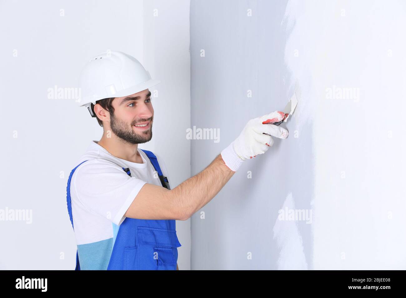 Young worker making repair in room Stock Photo - Alamy