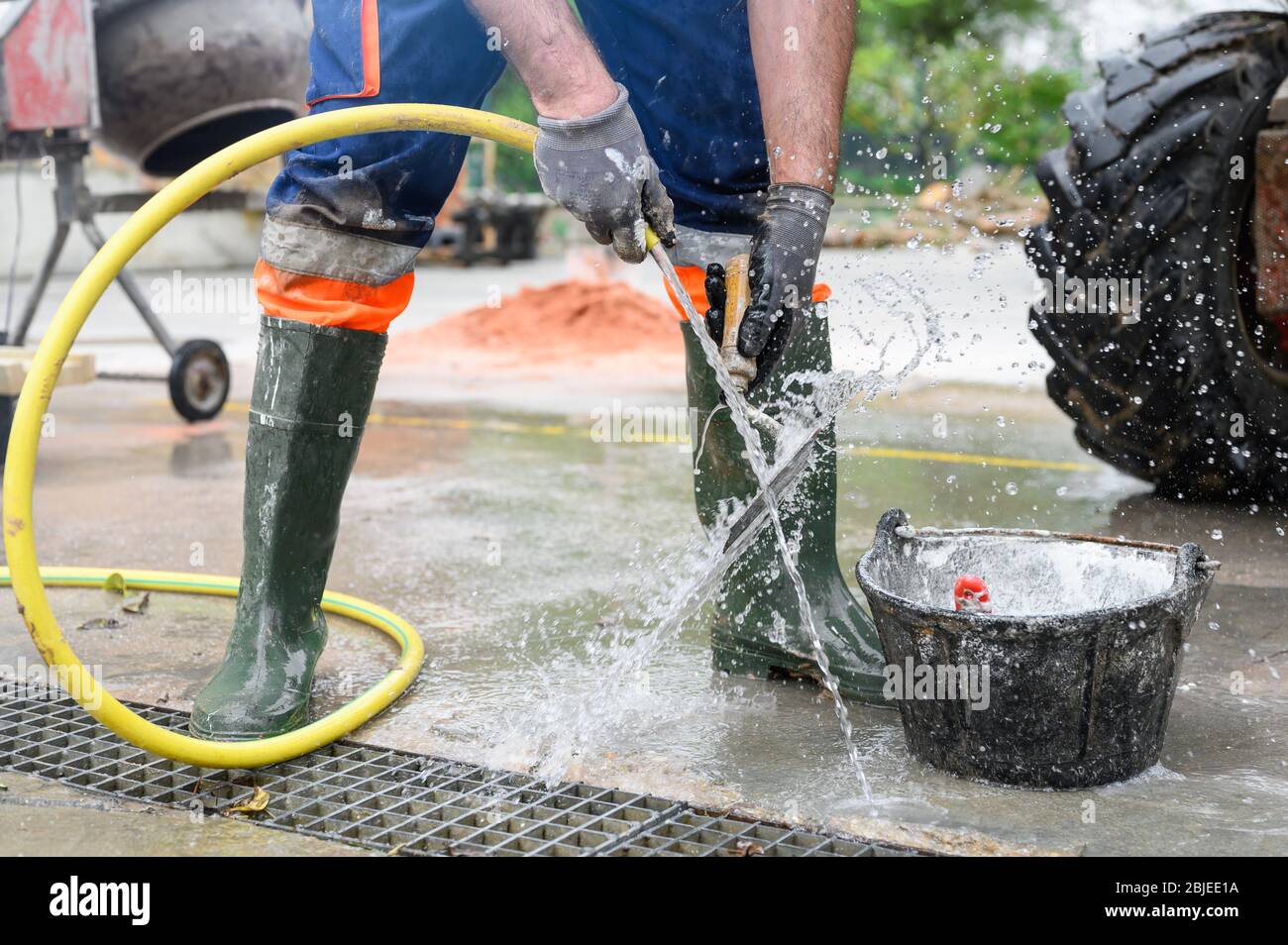 Construction worker washing tools at construction site road street ...