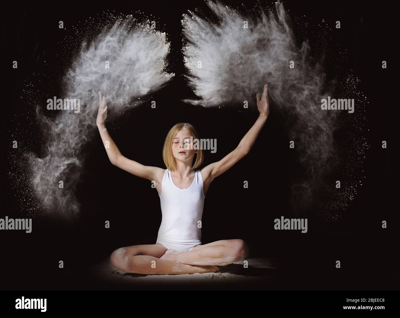 Little cute girl with white powder exploding around her on black ...