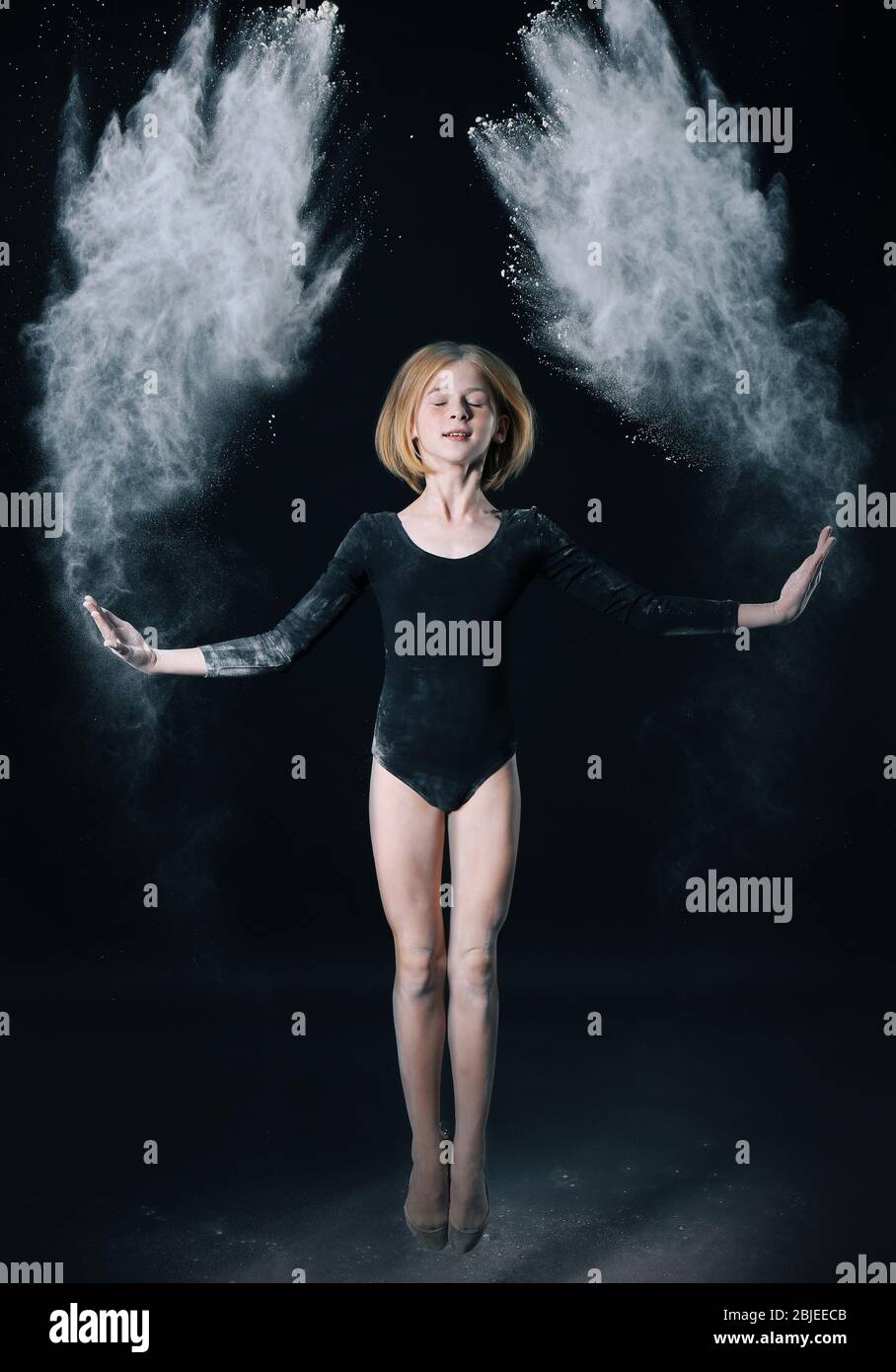 Little cute girl dancing with white powder on black background Stock ...