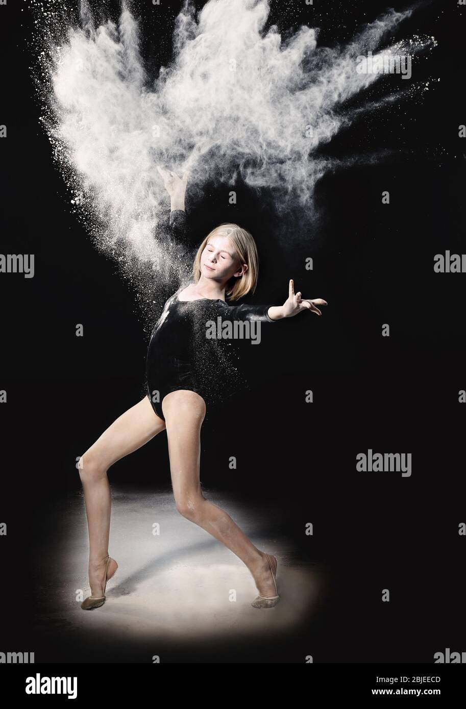 Little cute girl dancing with white powder on black background Stock ...