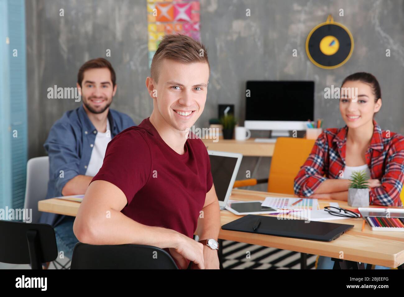 Three young designers at workplace Stock Photo - Alamy