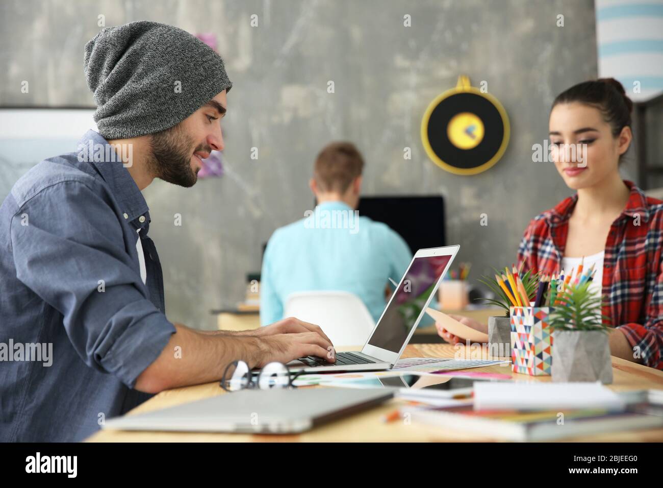 Three young designers at workplace Stock Photo - Alamy