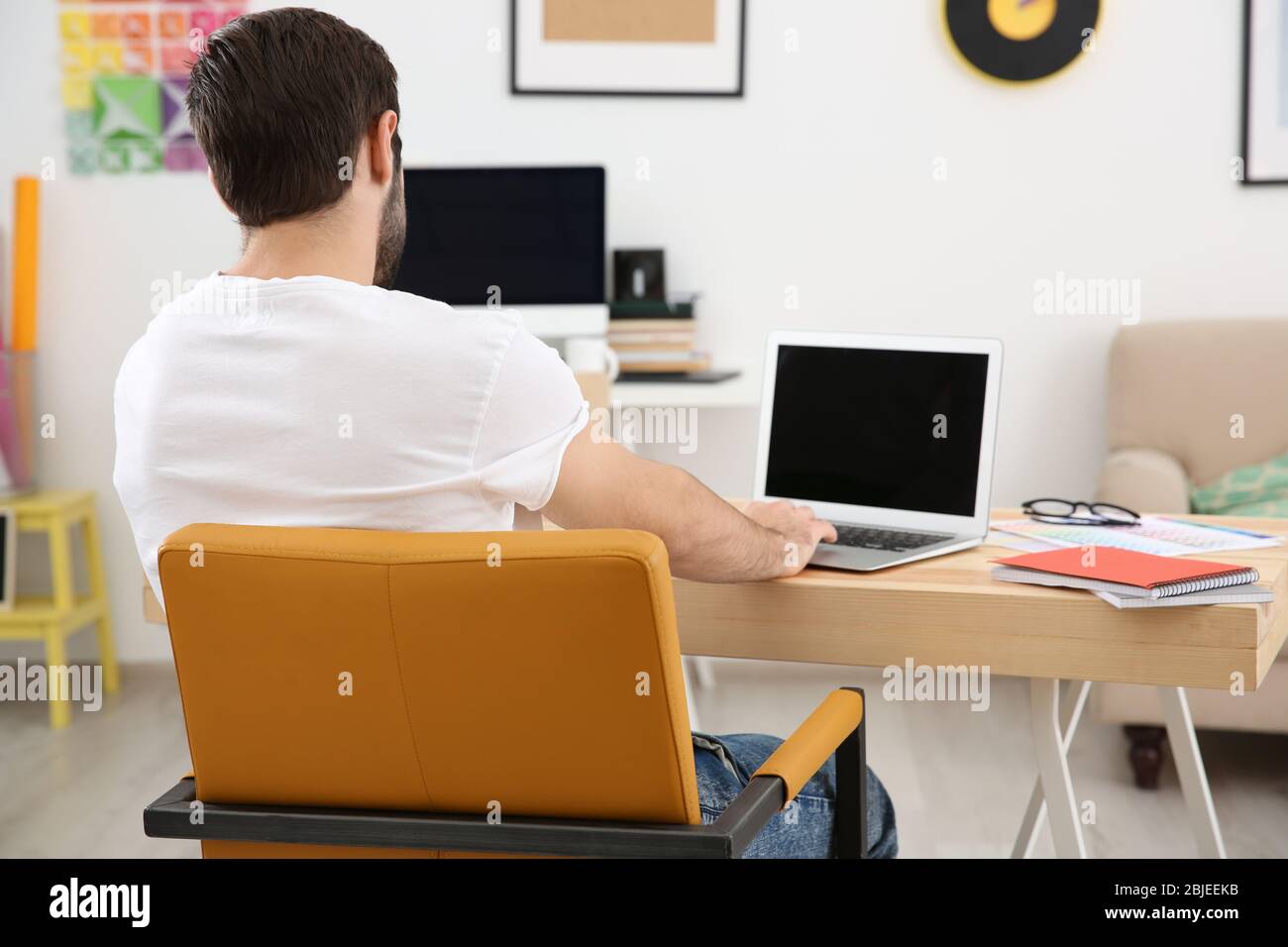 Back view of young man at workplace Stock Photo - Alamy