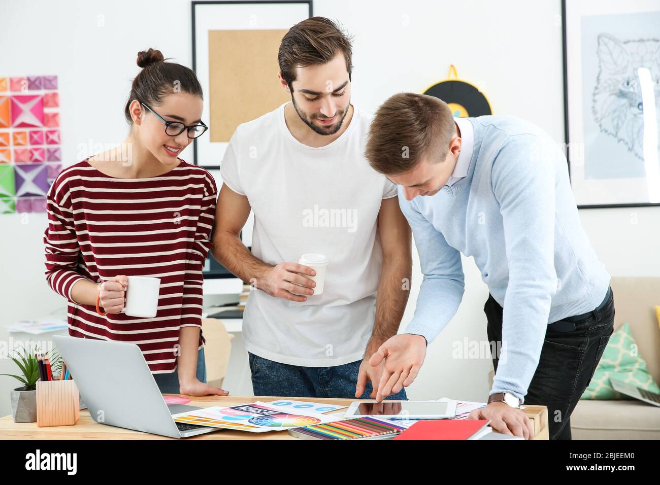 Three young designers at workplace Stock Photo - Alamy