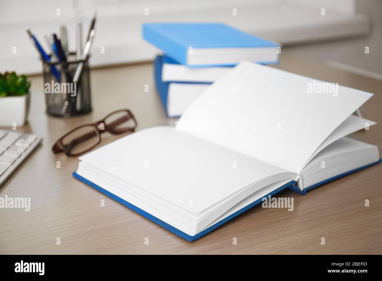 Open book on wooden table Stock Photo - Alamy