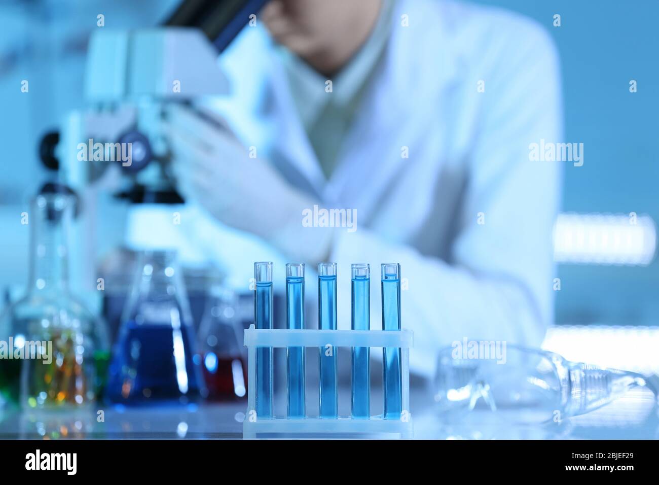 Test tubes with blue samples on laboratory background Stock Photo - Alamy