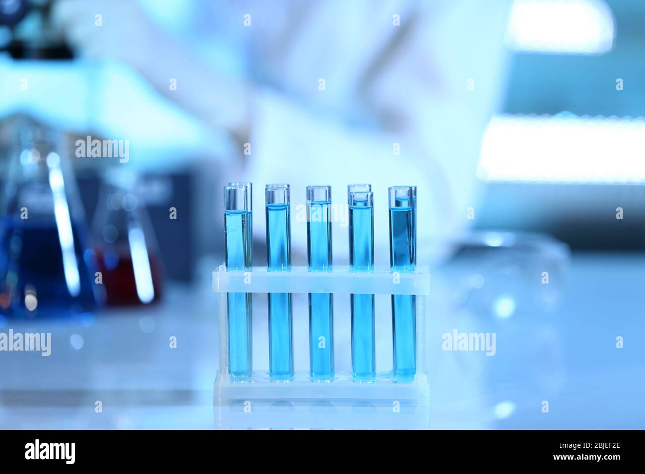 Test tubes with blue samples on laboratory background Stock Photo - Alamy