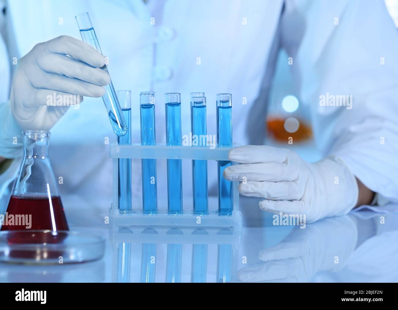 Scientist putting test tube on holder Stock Photo - Alamy