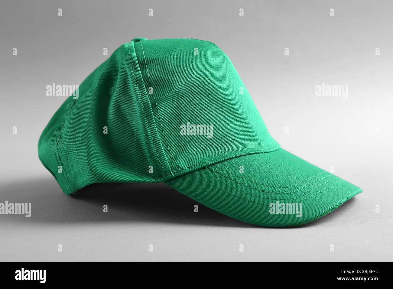 Blank green baseball cap on grey background Stock Photo - Alamy