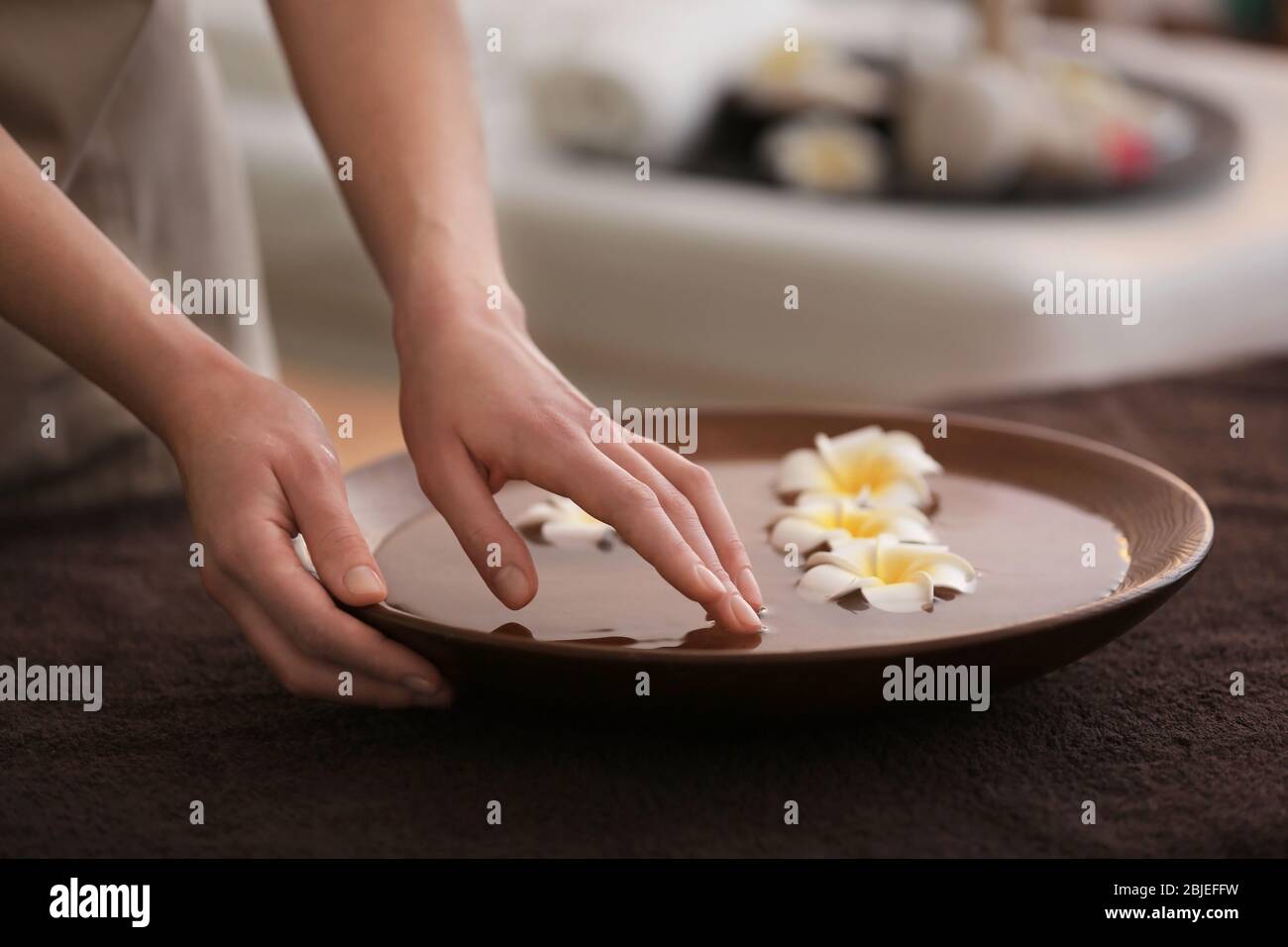 Spa concept. Female hands with bowl and exotic flowers Stock Photo - Alamy