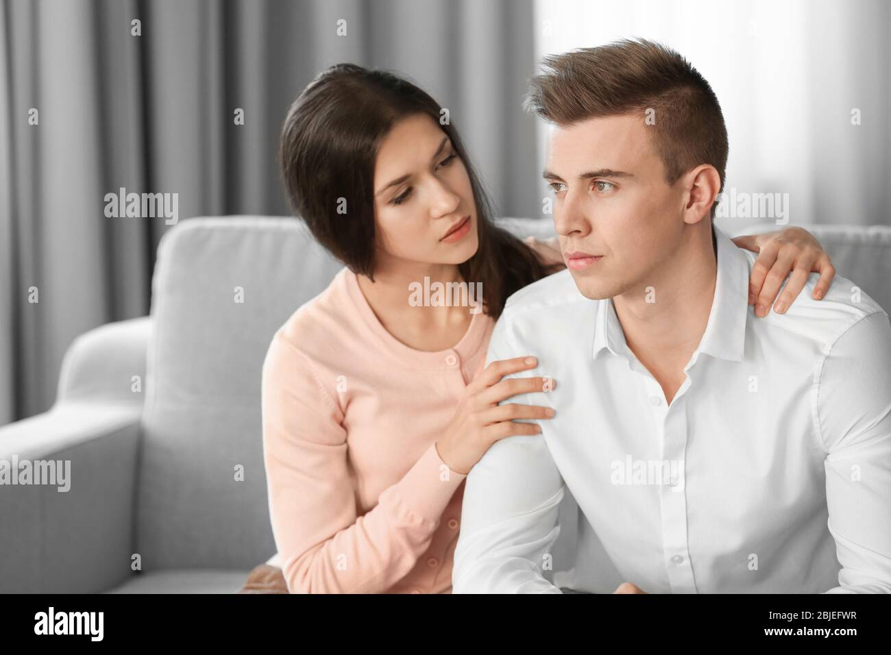 Young depressed man with girlfriend at home Stock Photo - Alamy