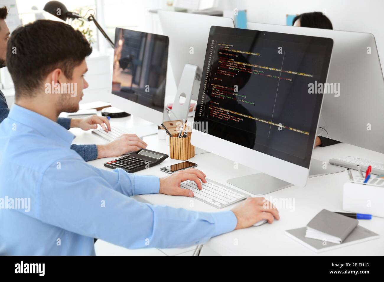 Handsome young programmer working in office Stock Photo - Alamy