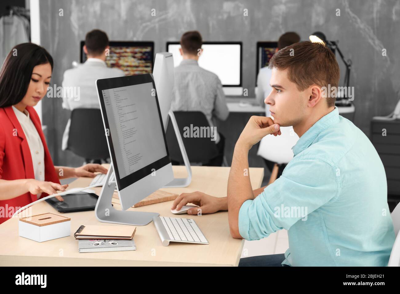Young programmers working in office Stock Photo - Alamy