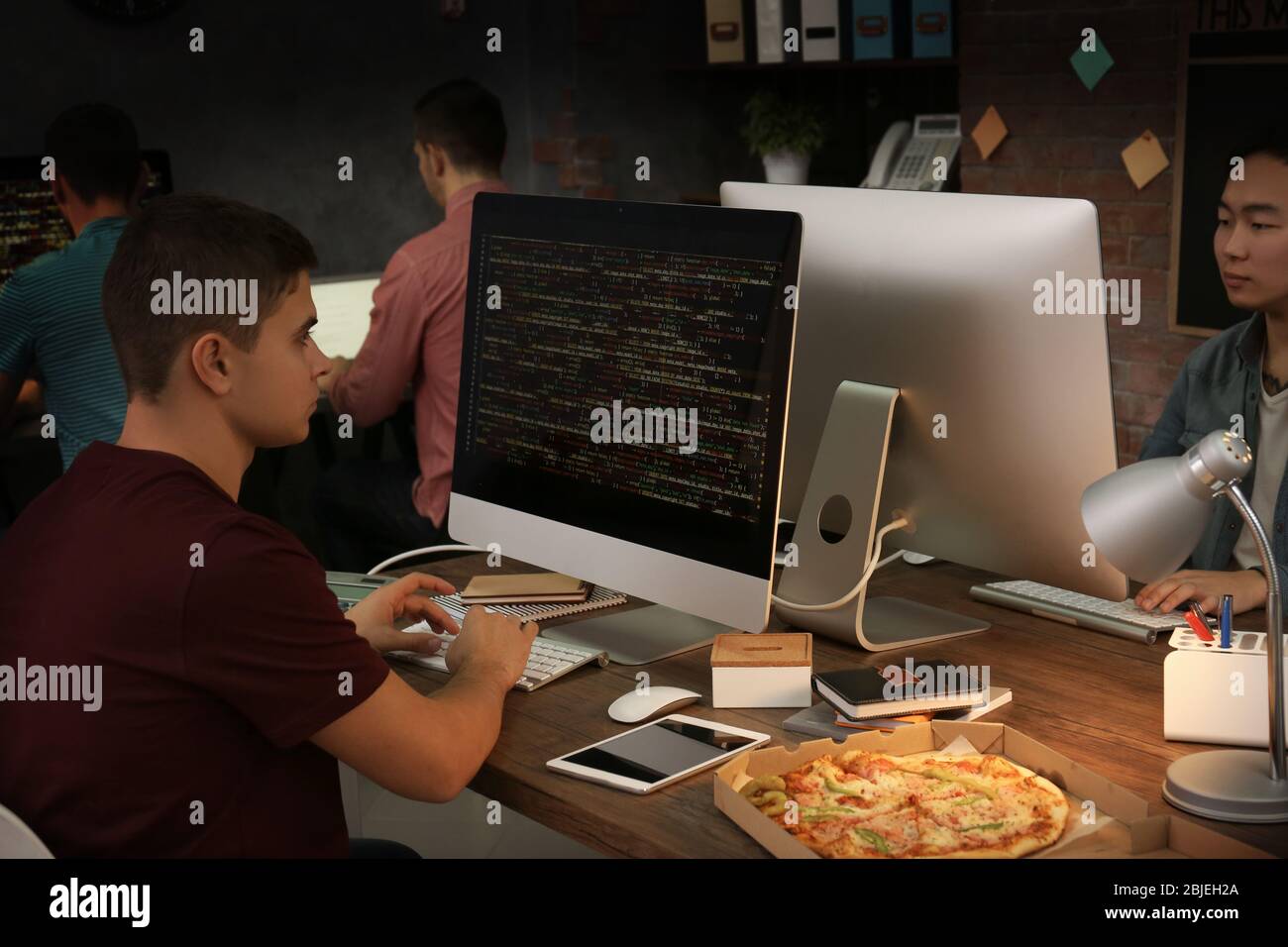 Young programmers working in office Stock Photo - Alamy