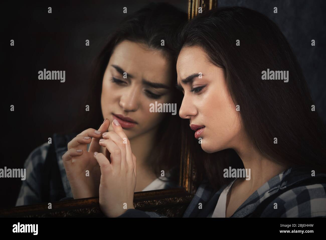 Woman looking mirror sad touching face hi-res stock photography and ...