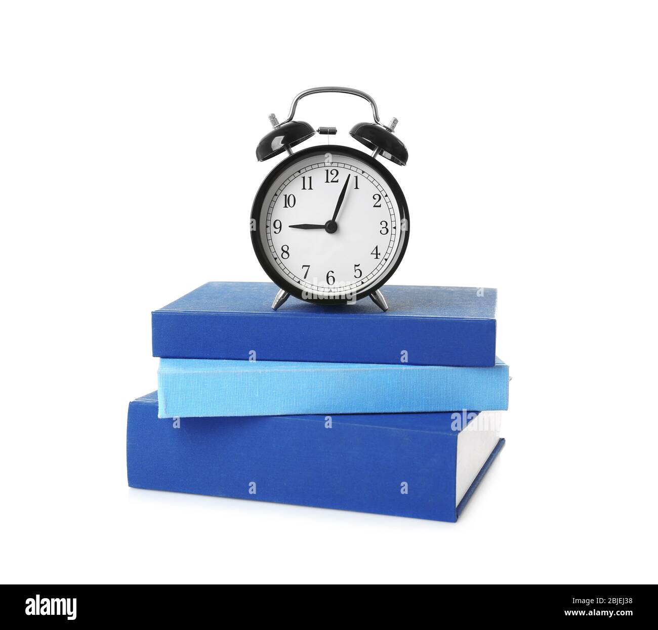 Alarm clock and stack of books on white background Stock Photo - Alamy