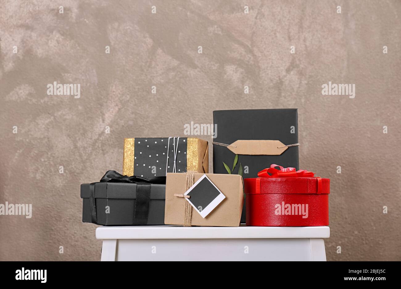 Stylish present boxes on textured wall background Stock Photo - Alamy