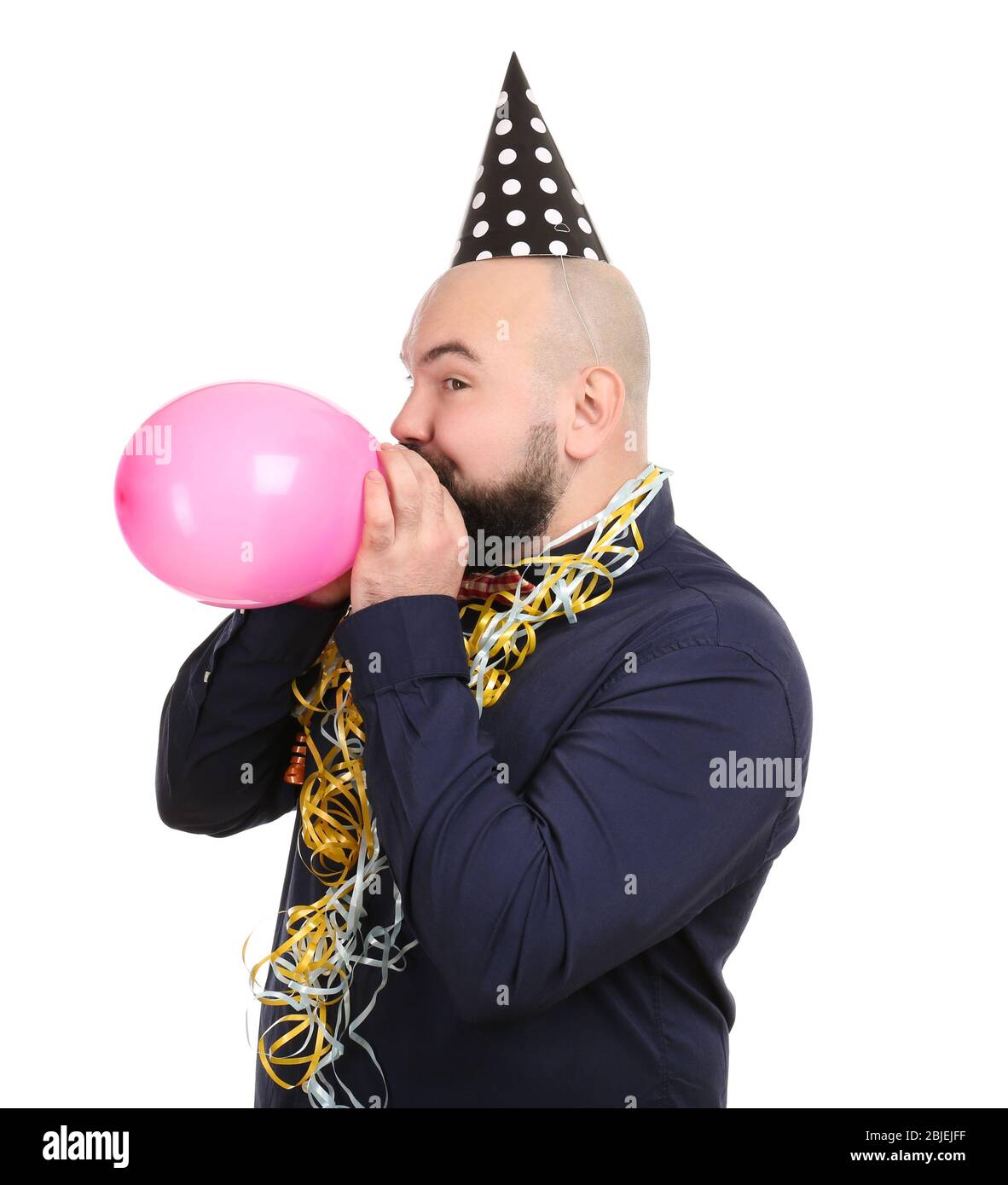 Funny fat man with birthday decor inflating balloon on white background ...