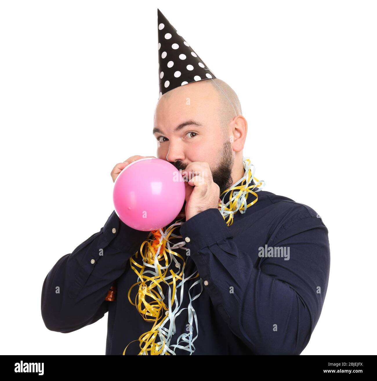 Funny fat man with birthday decor inflating balloon on white background ...