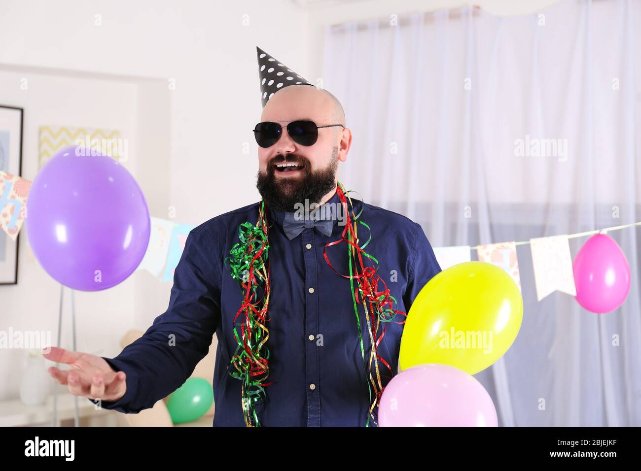 Funny fat man celebrating birthday at home Stock Photo - Alamy