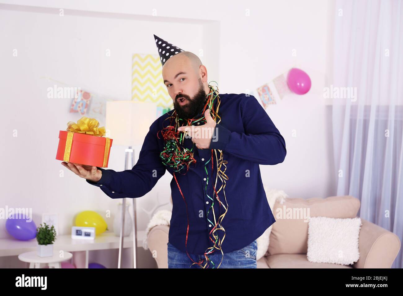 Funny fat man celebrating birthday at home Stock Photo - Alamy