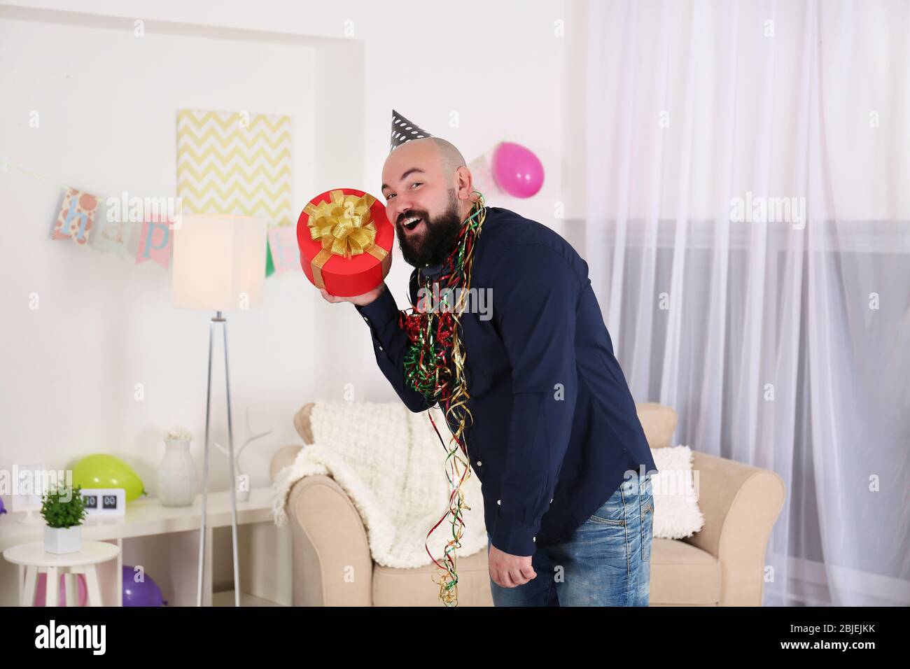 Funny fat man celebrating birthday at home Stock Photo - Alamy