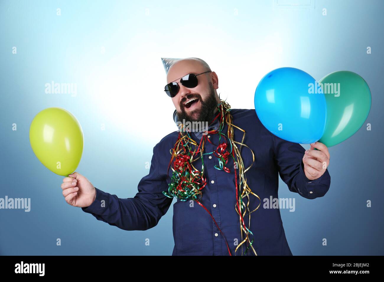 Funny fat man with birthday hat and balloons on color background Stock ...