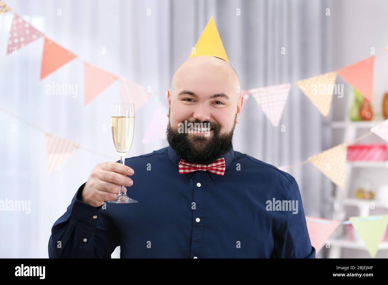 Funny fat man celebrating birthday at home Stock Photo - Alamy