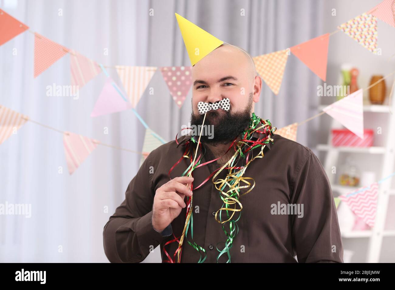 Funny fat man celebrating birthday at home Stock Photo - Alamy