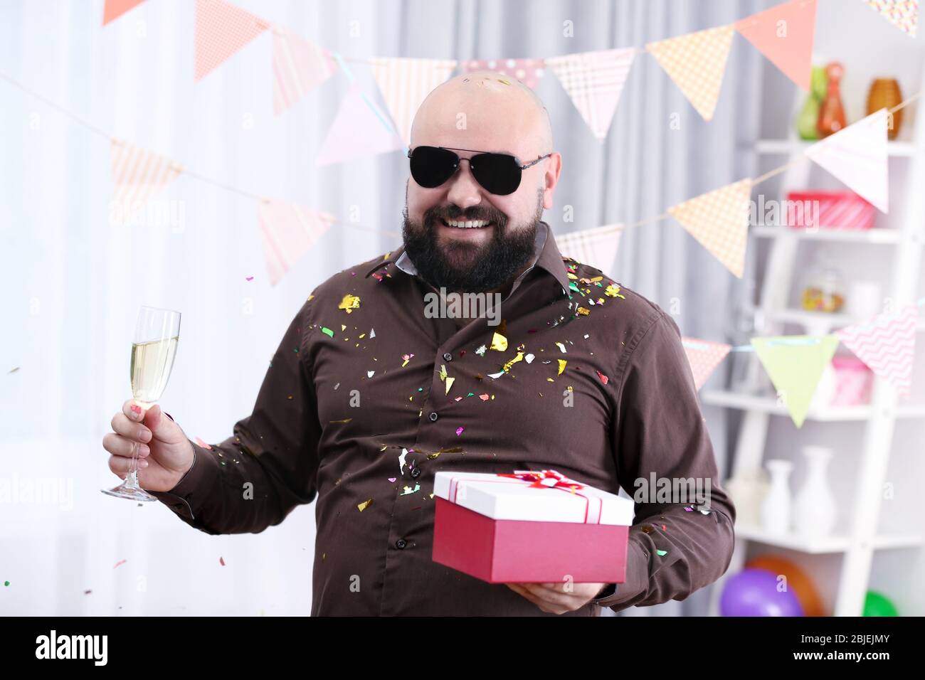 Funny fat man celebrating birthday at home Stock Photo - Alamy